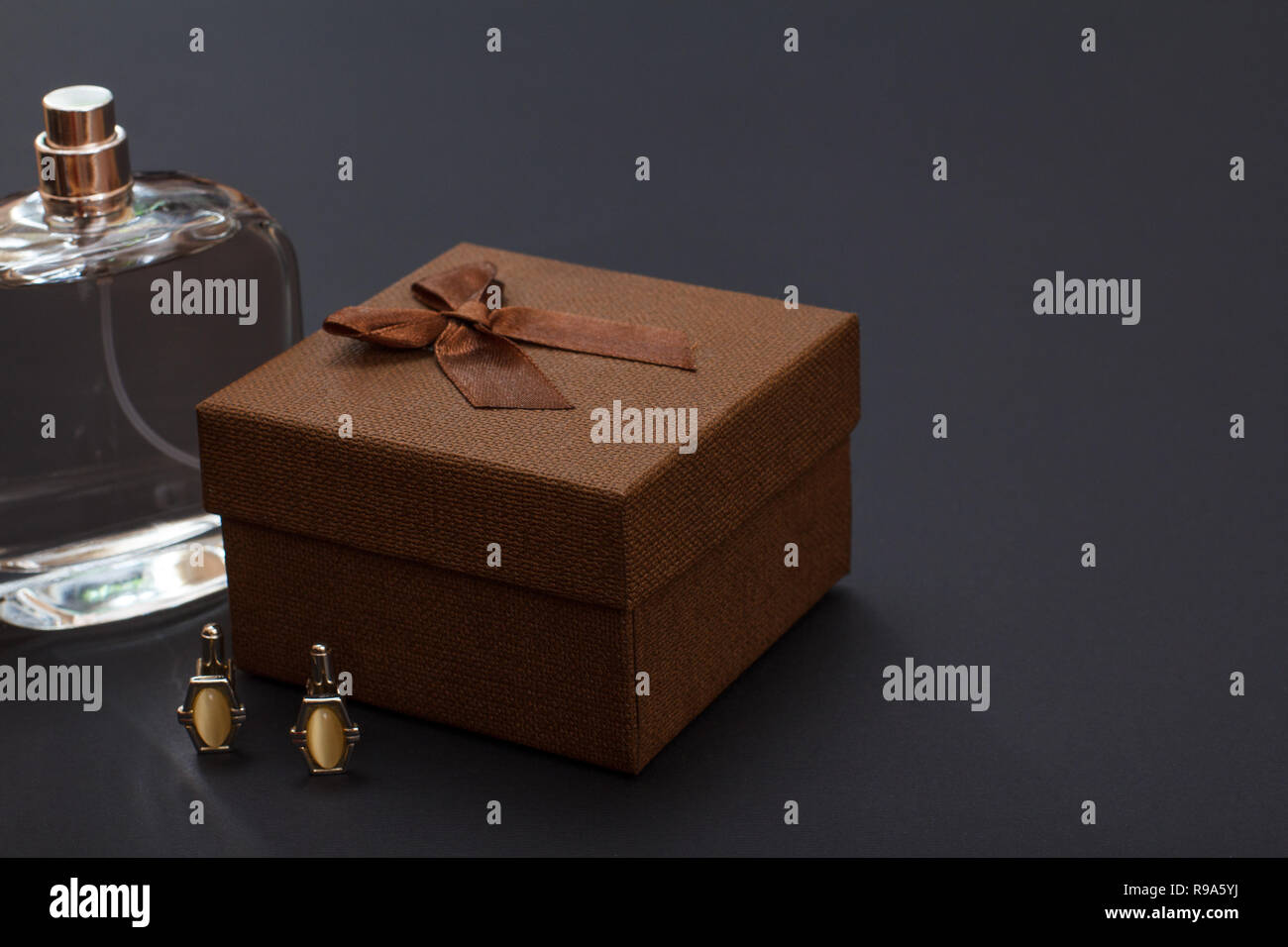Cologne for men, brown gift box and cufflinks on black background ...