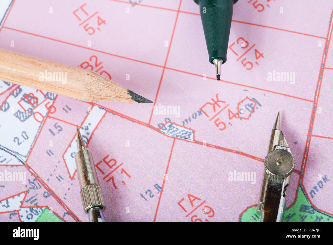 Topographic map of district with a measuring instrument and pencils ...