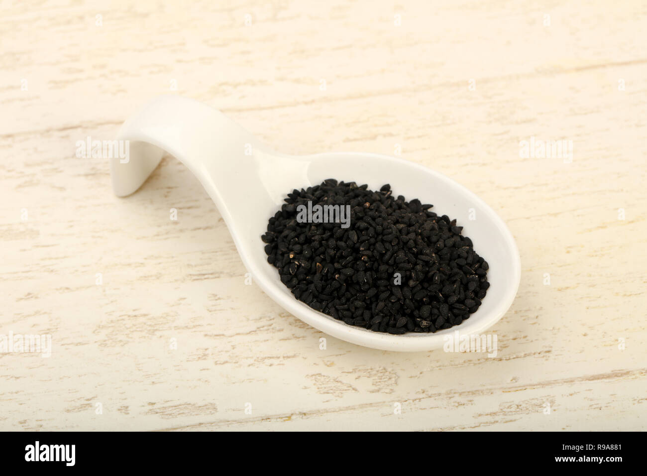 Black nigella seeds heap over wooden background Stock Photo - Alamy