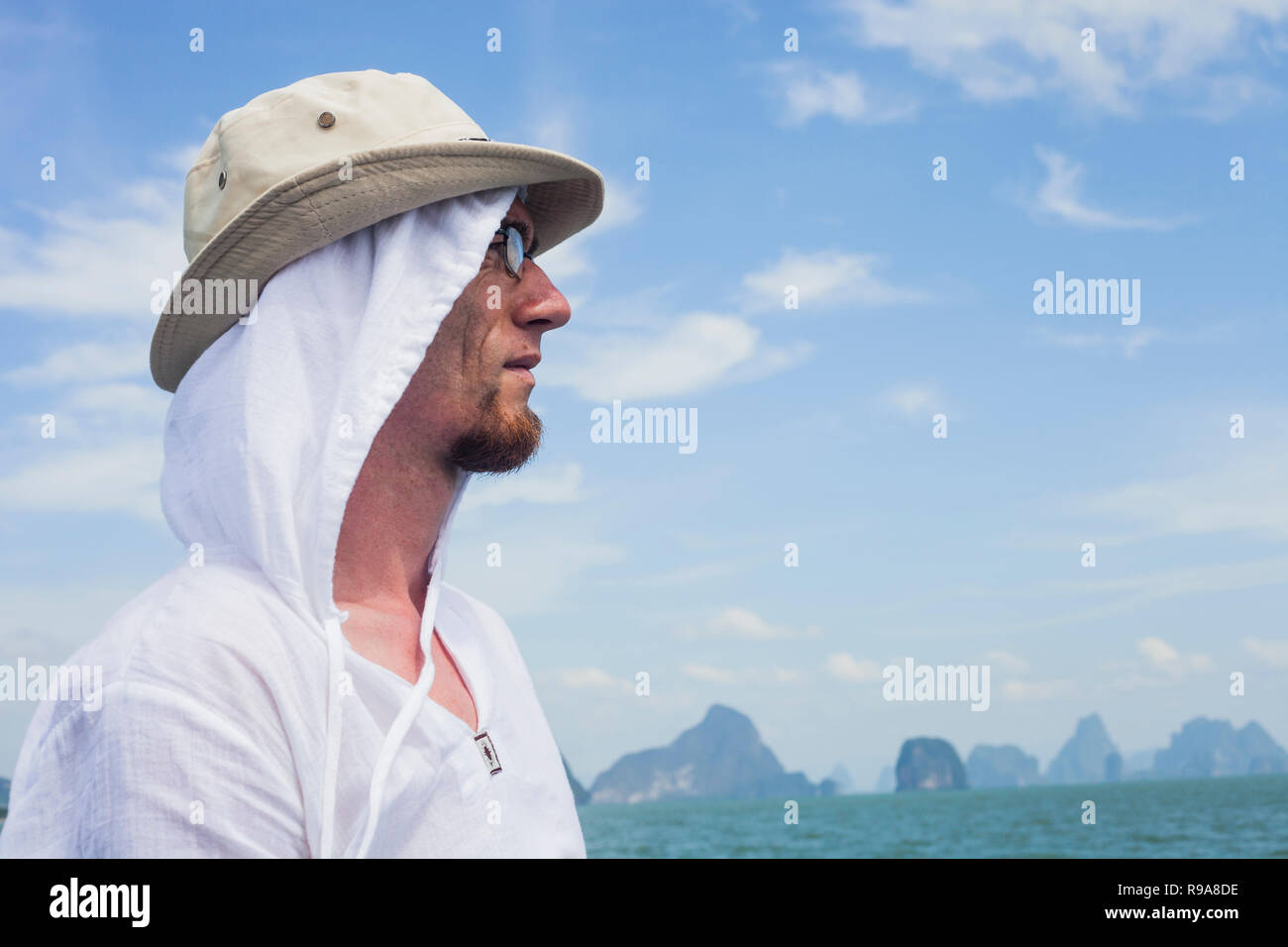 Young man on blue sea and islands silhouettes background, summer ...