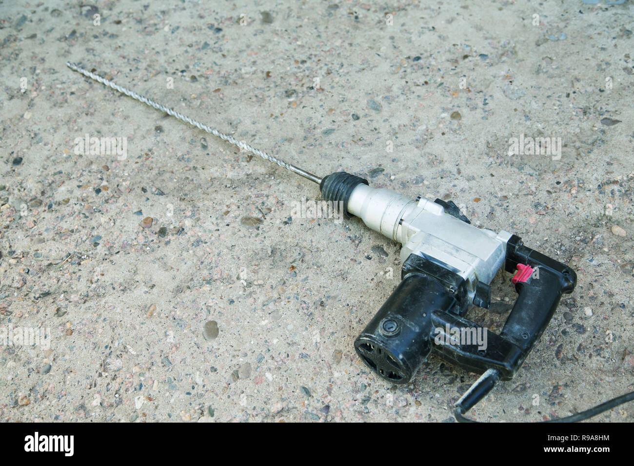 perforator with a long drill rests on a concrete surface Stock Photo ...