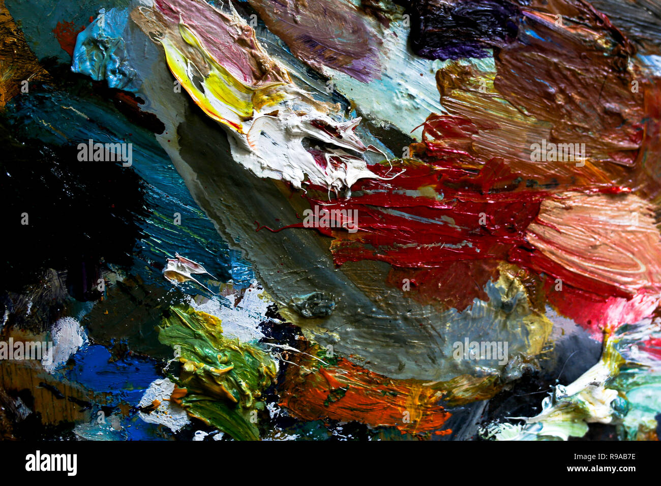 multi-colored strokes of oil paint on the artist's palette. the texture ...