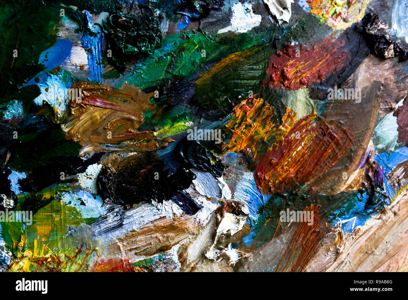 multi-colored strokes of oil paint on the artist's palette. the texture ...