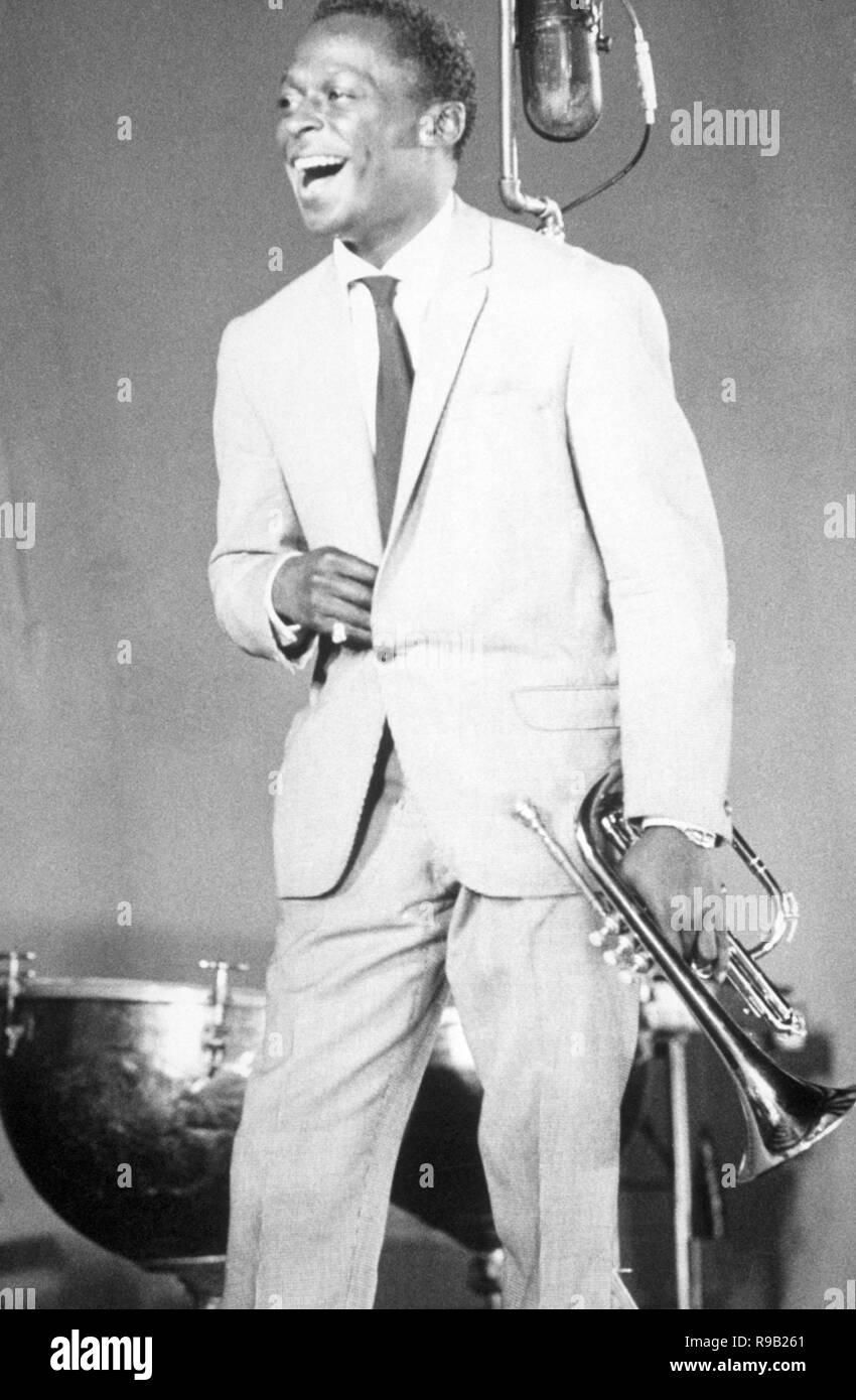 American jazz trumpeter and bandleader Miles Davis laughs while holding ...