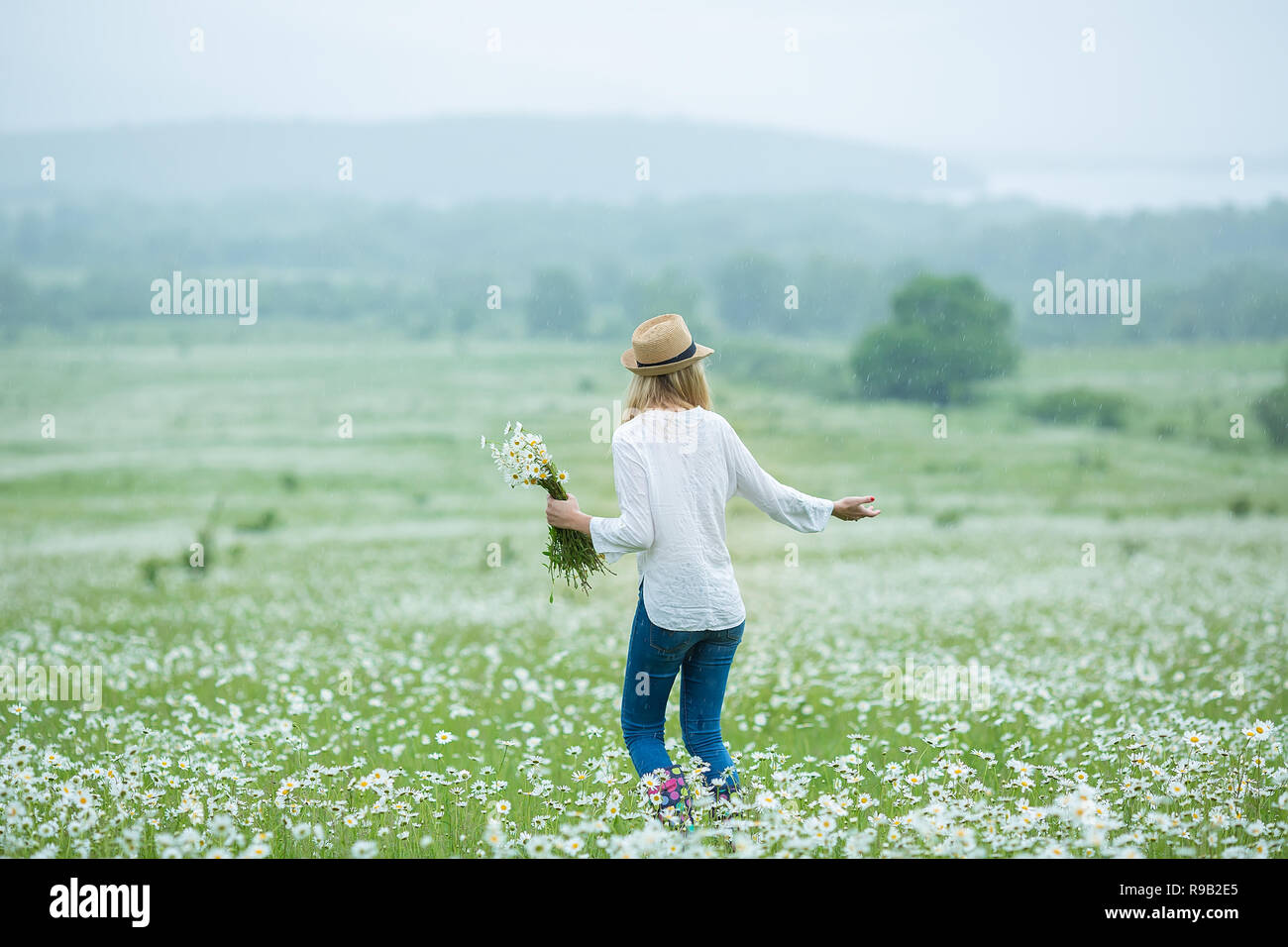 beautiful blond girl lady woman on green field with flowers chamomile ...