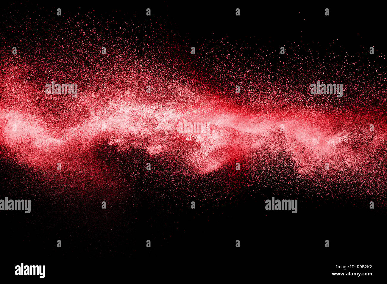Red color powder explosion on black background.Freeze motion of red ...