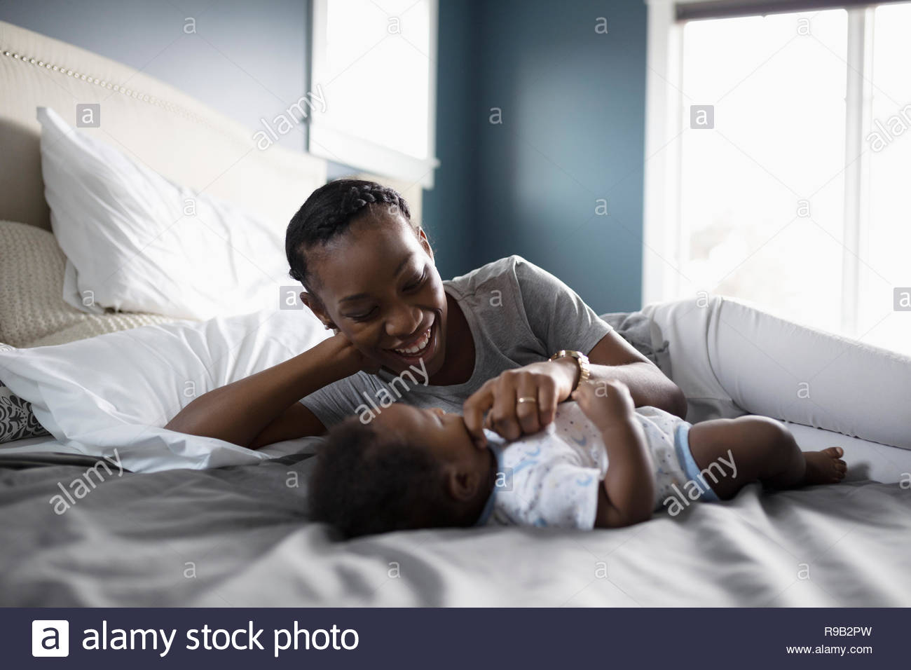 Affectionate mother and baby on bed Stock Photo - Alamy