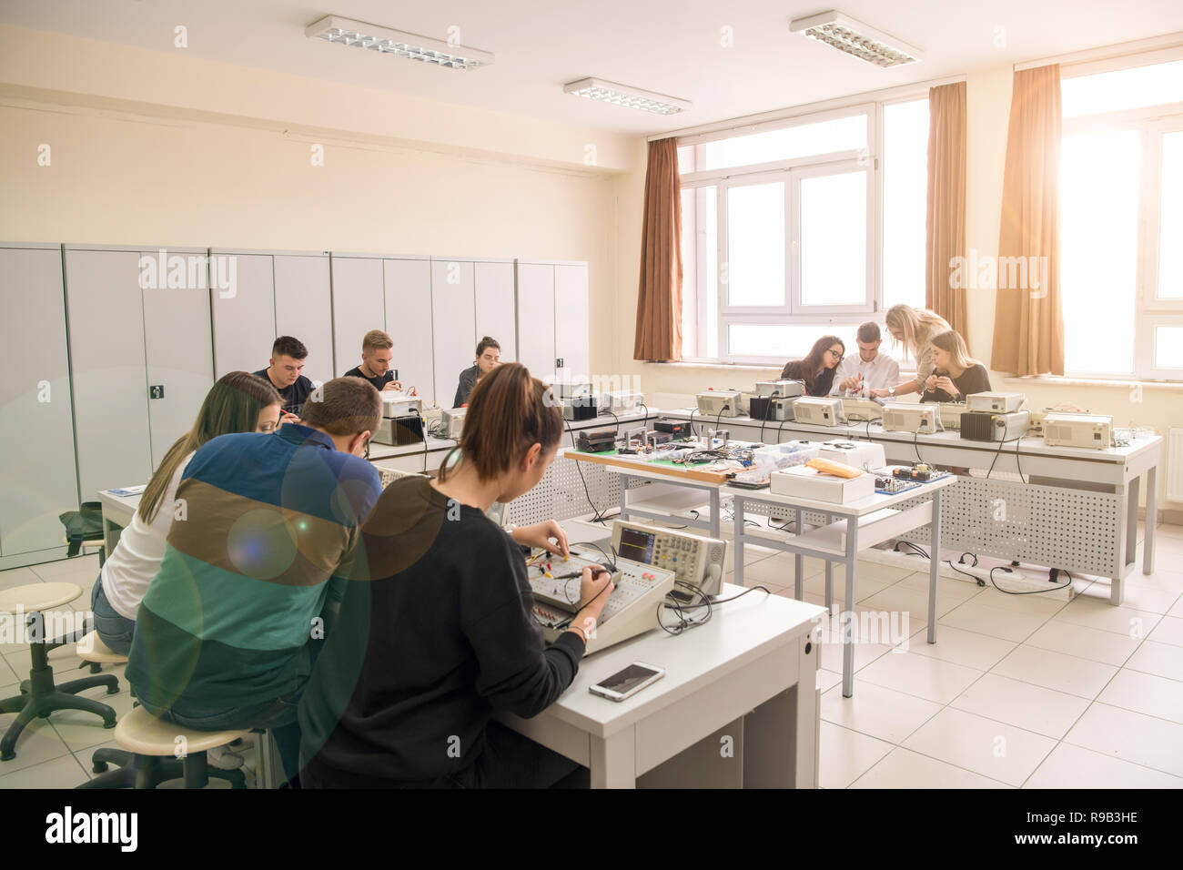 Group of young students doing technical vocational practice with ...