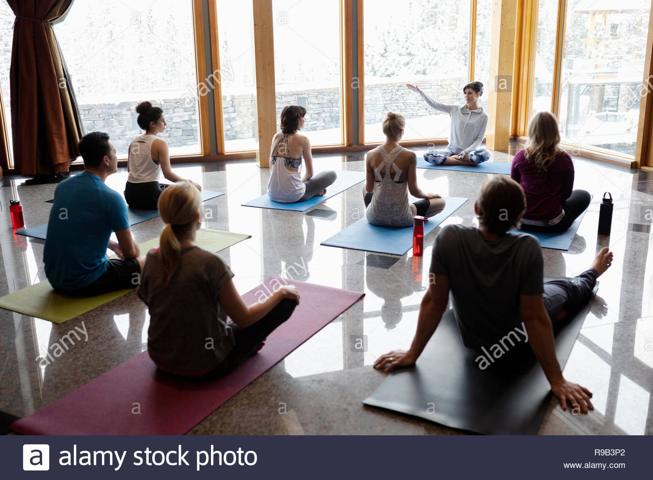 Female instructor leading yoga class in studio Stock Photo - Alamy