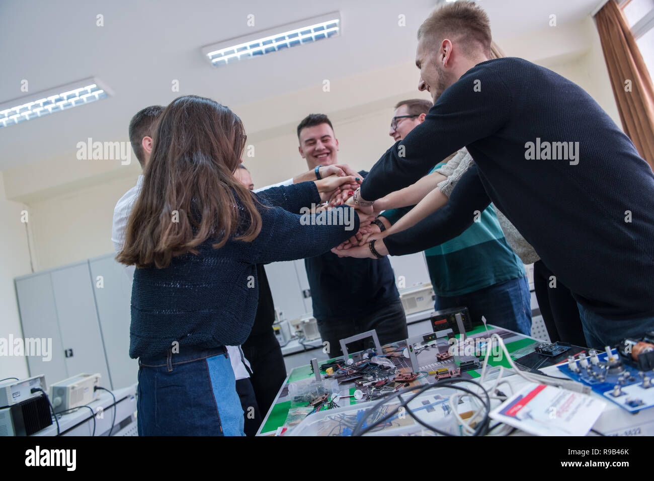Group of young students in electronics classroom celebrating ...