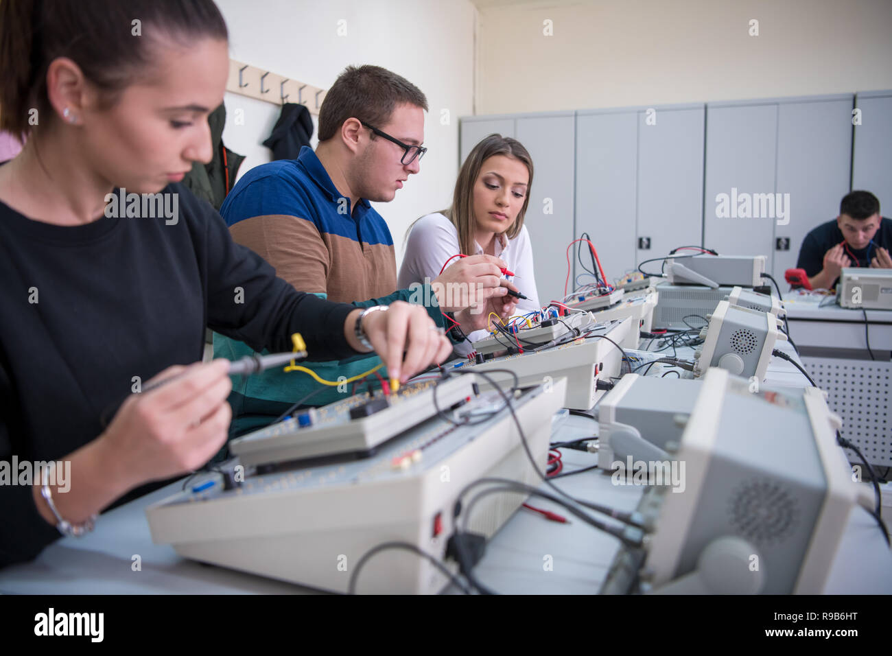 Group of young students doing technical vocational practice with ...