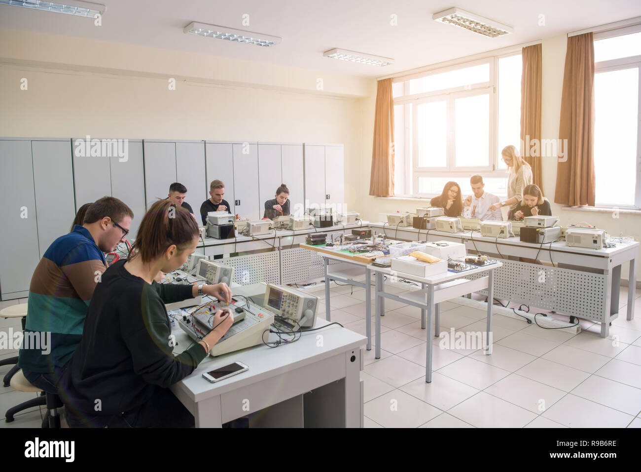 Group of young students doing technical vocational practice with ...