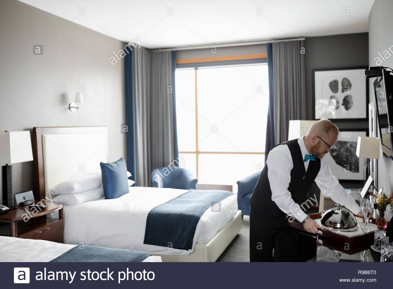 Male hotel staff waiter serving food in luxury hotel room Stock Photo ...