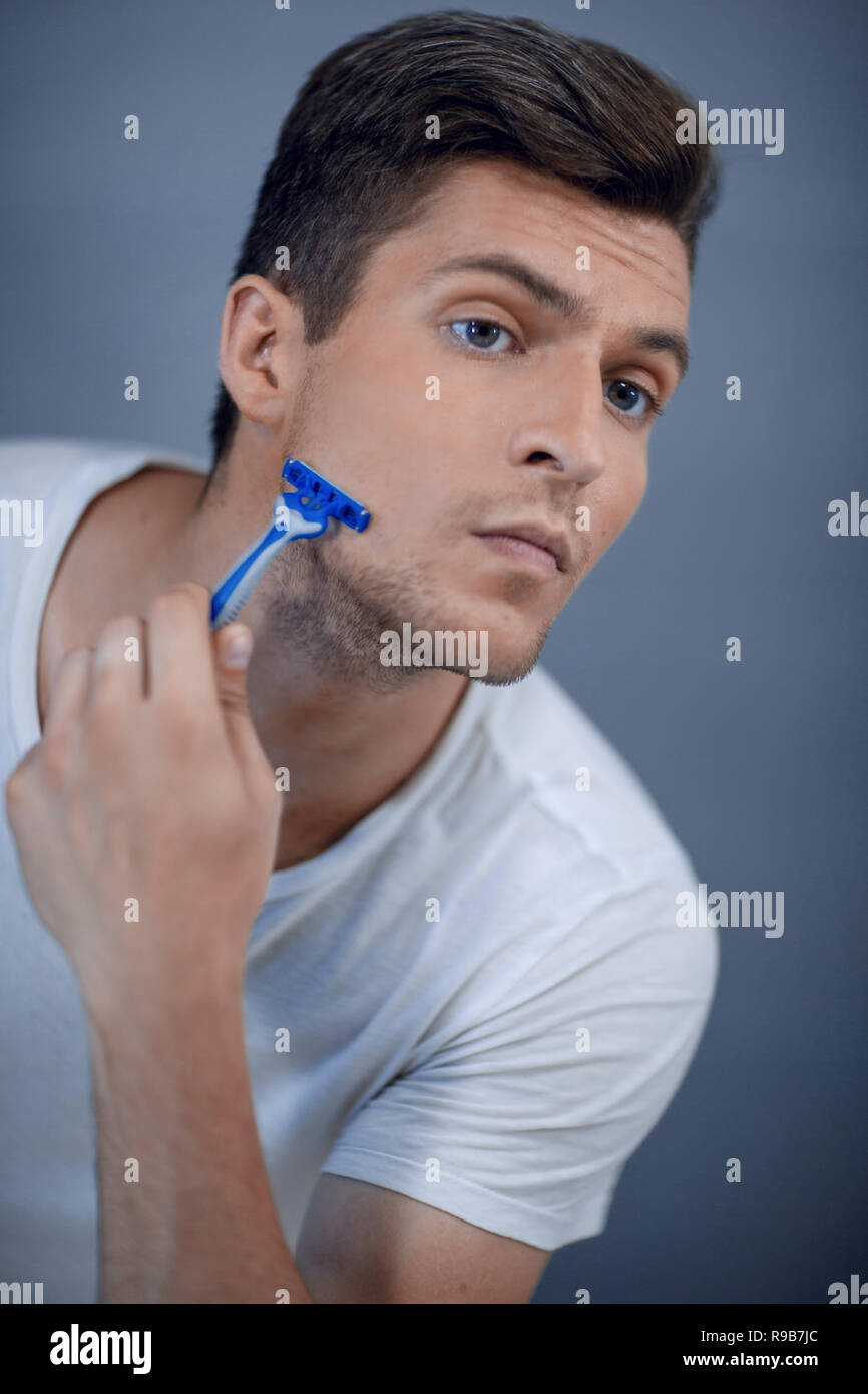 close up. stylish modern guy shaves his face Stock Photo - Alamy