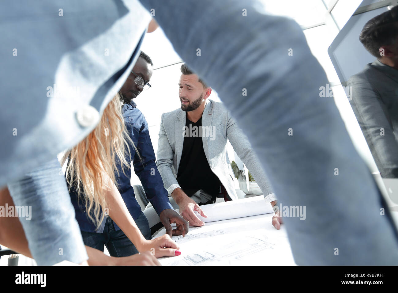 close up. a group of designers standing around the desktop Stock Photo ...