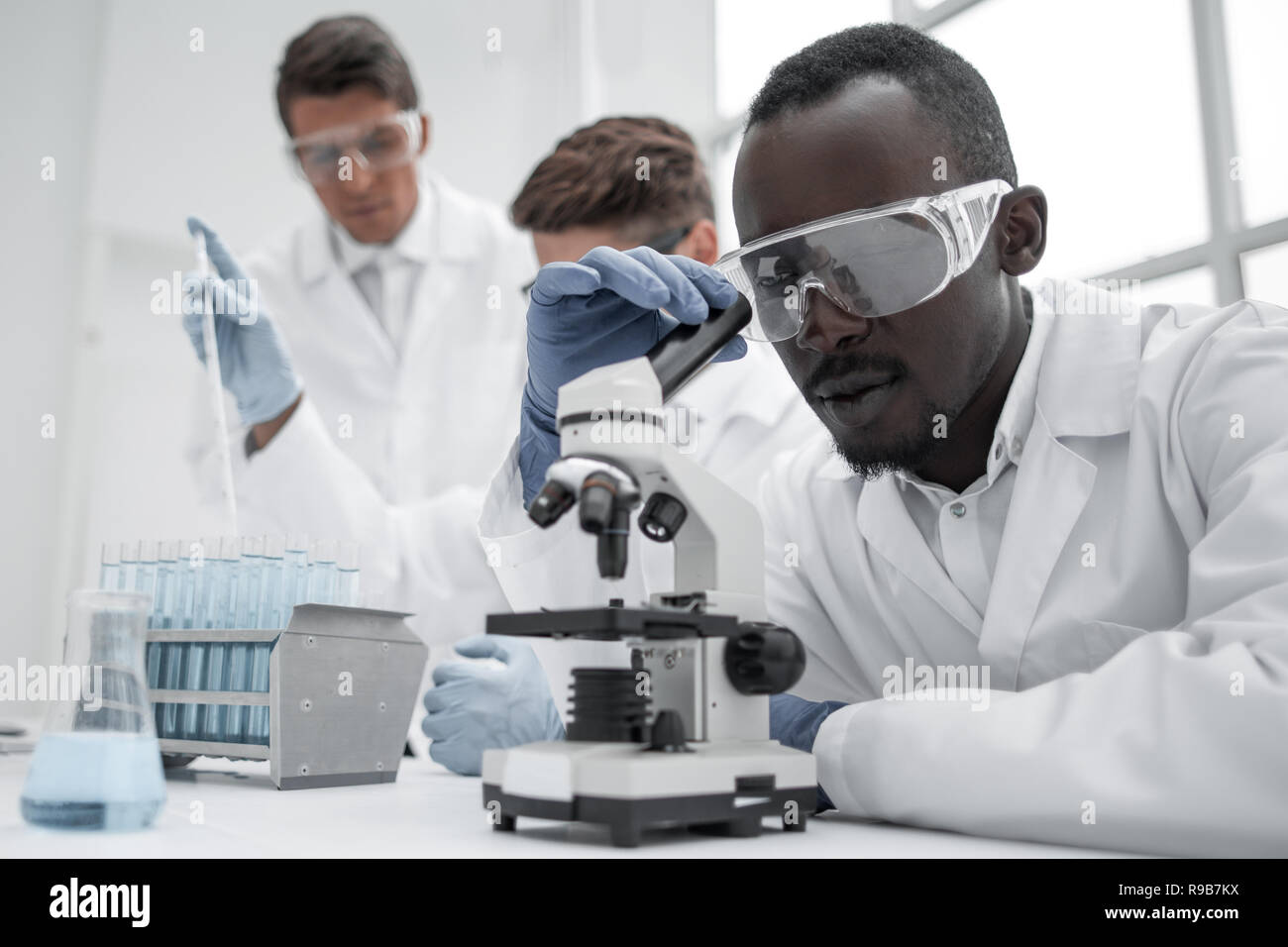 modern scientist looking through a microscope Stock Photo - Alamy