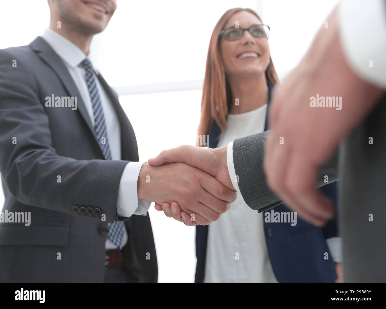 Business shaking hands in the office Stock Photo - Alamy