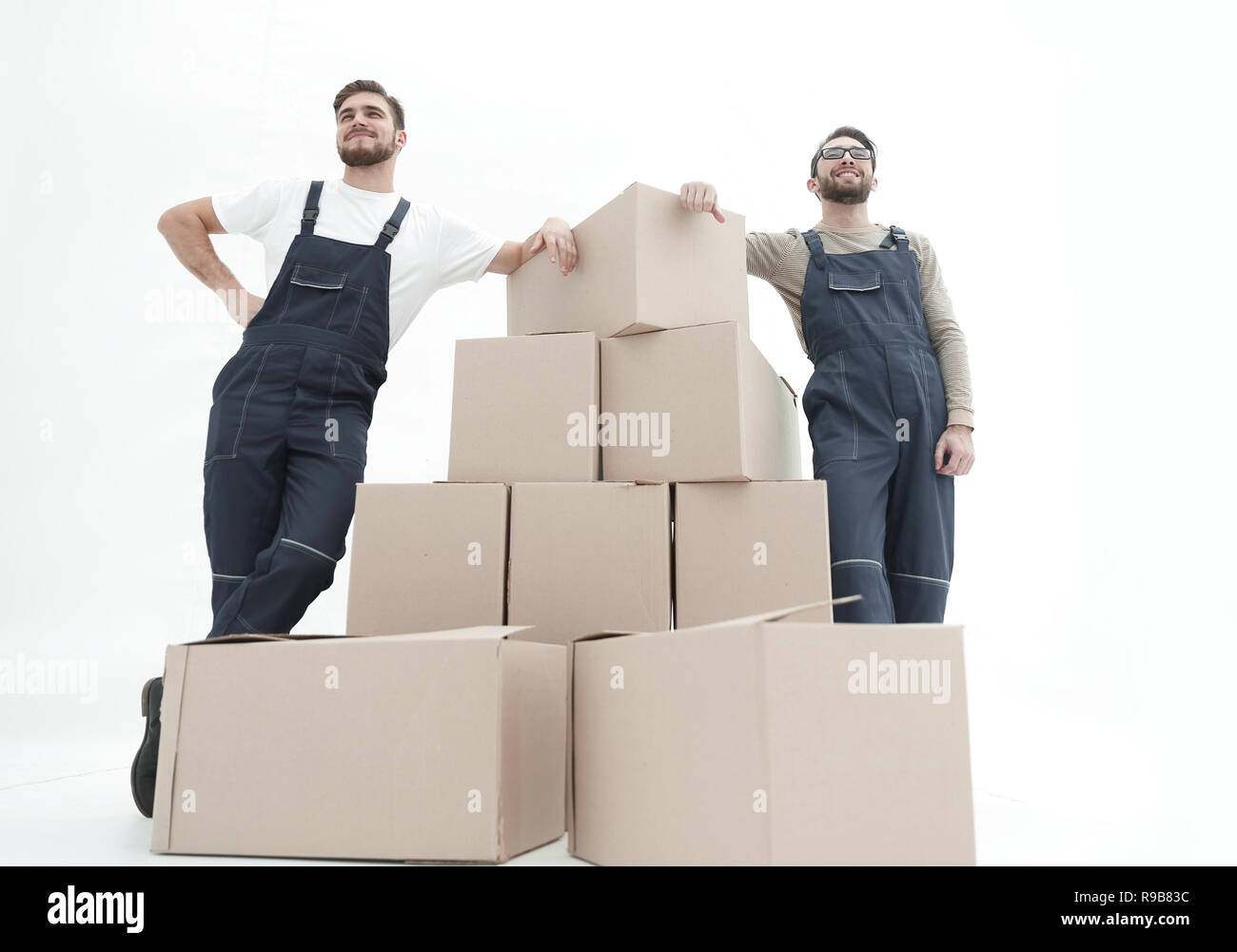 Young men carrying a box to the pile of boxes Stock Photo - Alamy