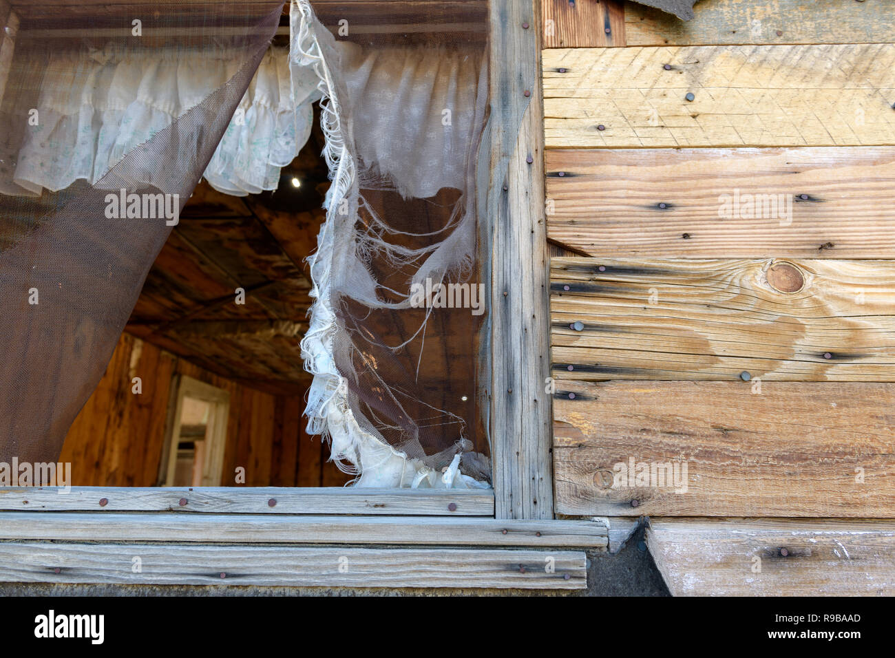 Window with a torn screen at Bonnie Claire Ghost Town in Nevada, USA ...