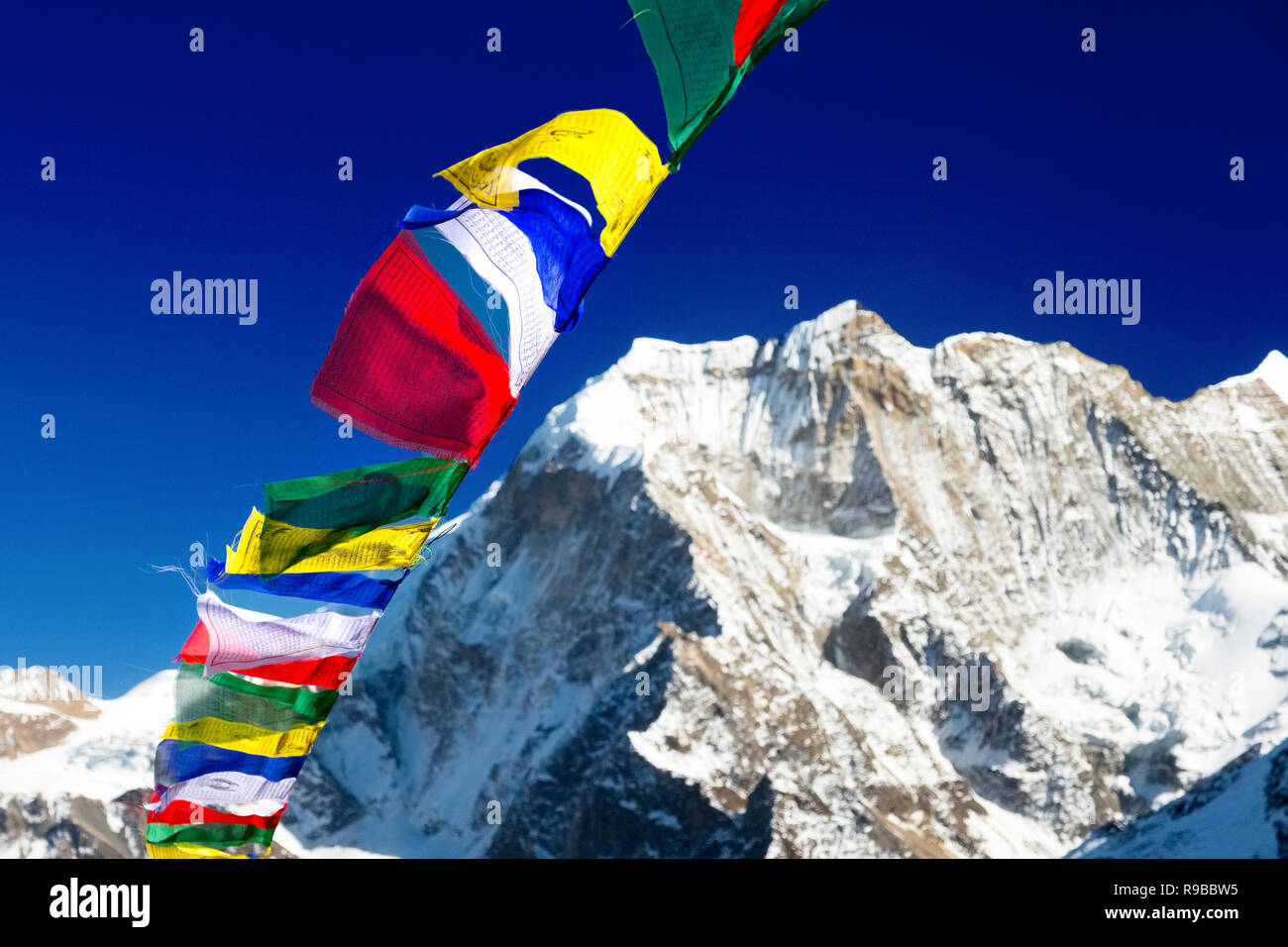 Prayer flags, blue sky and Himalayan mountain in the Manaslu region ...