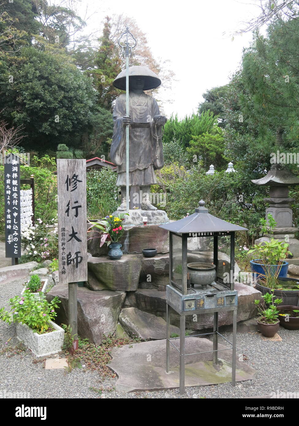 Statue and stone lanterns outside the entrance to the Taya Caves at ...