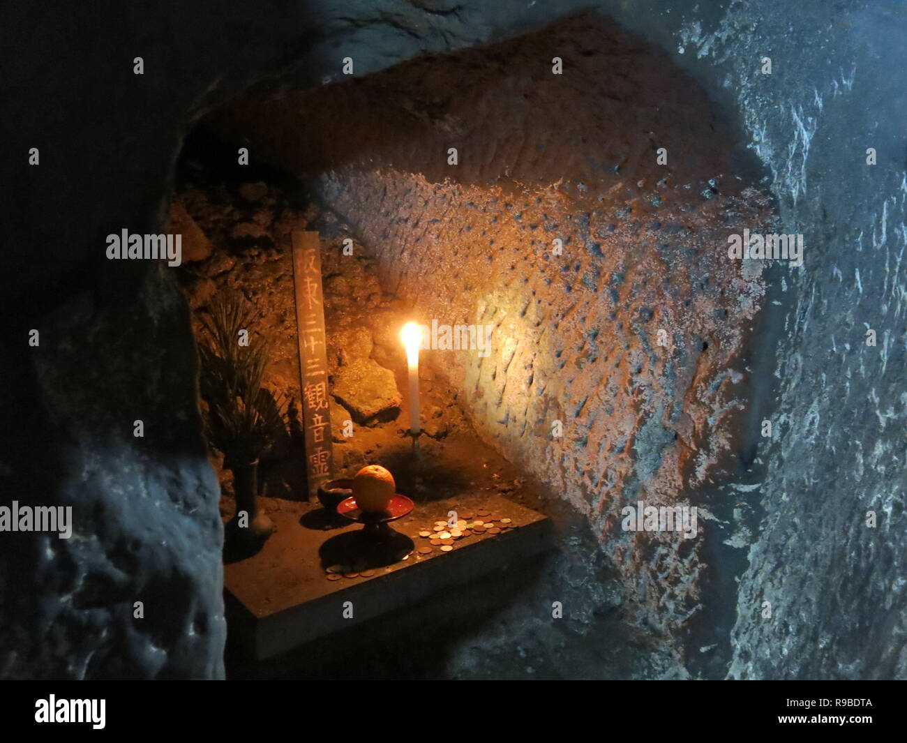 Candles light up the interior of the Taya Caves at Kamakura, carved ...