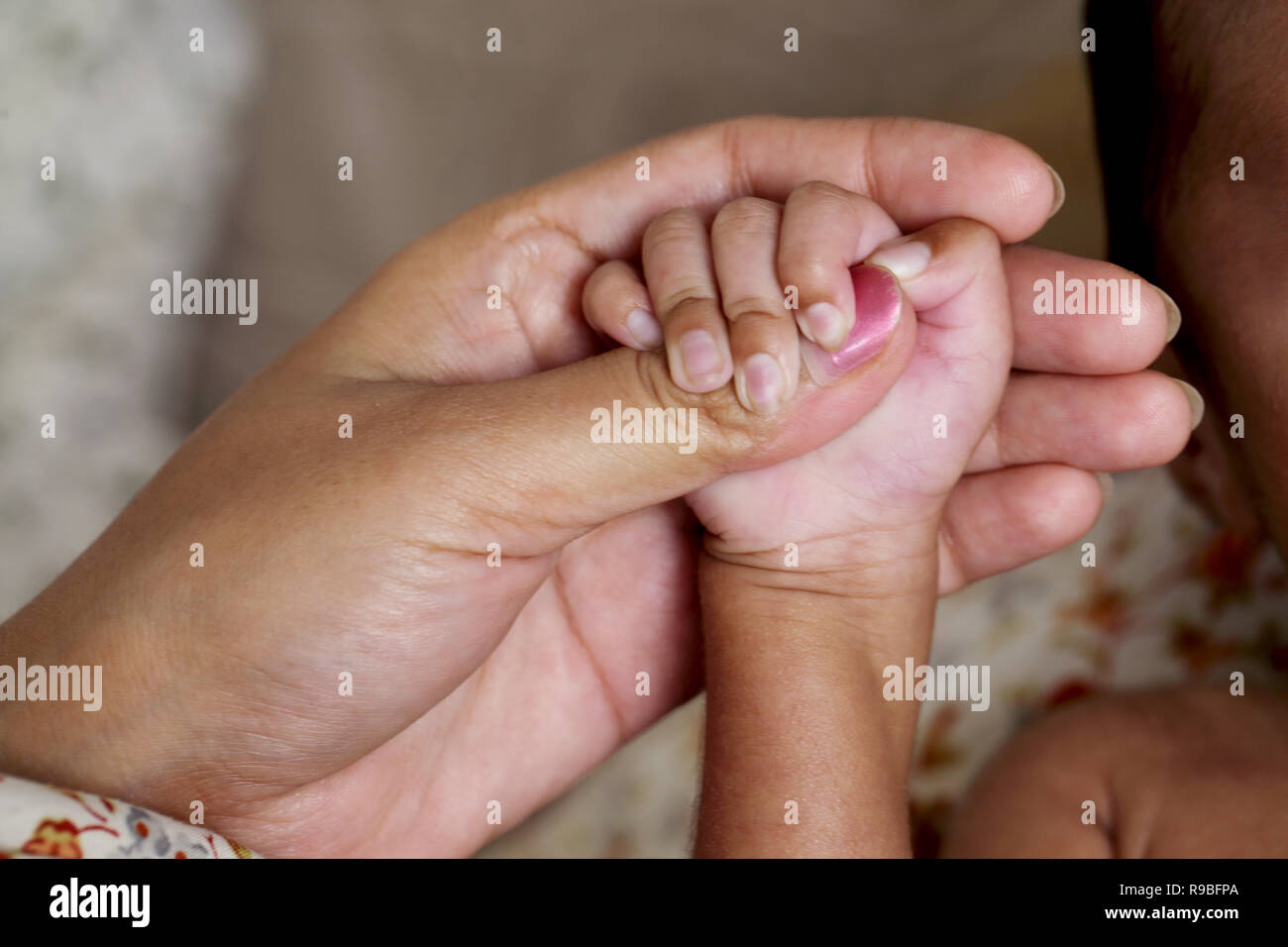 Sleeping baby holding mother's finger hi-res stock photography and ...