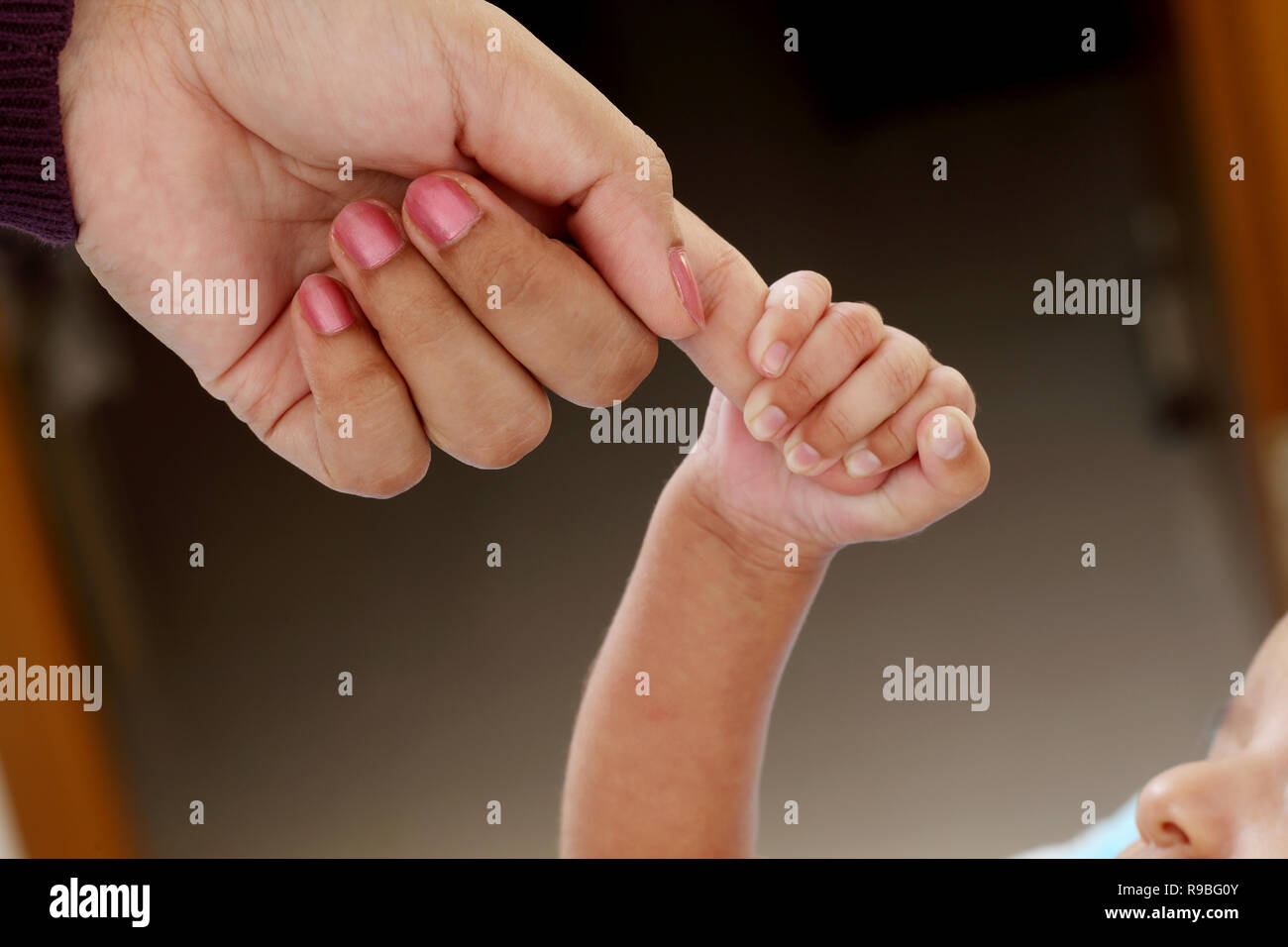 Newborn baby gripping mothers finger Stock Photo - Alamy
