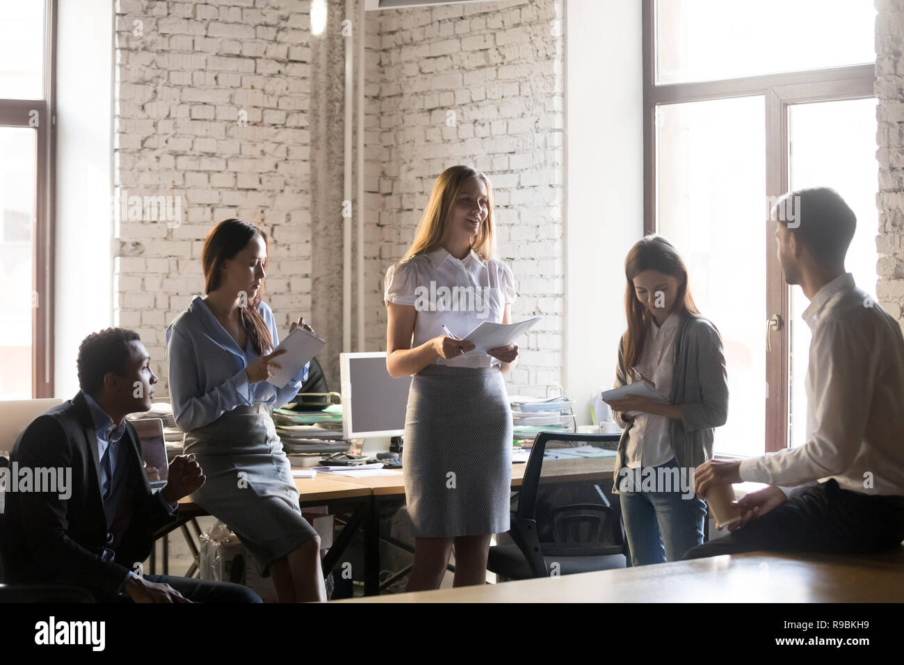 Female team leader talking to team employees at group meeting Stock ...