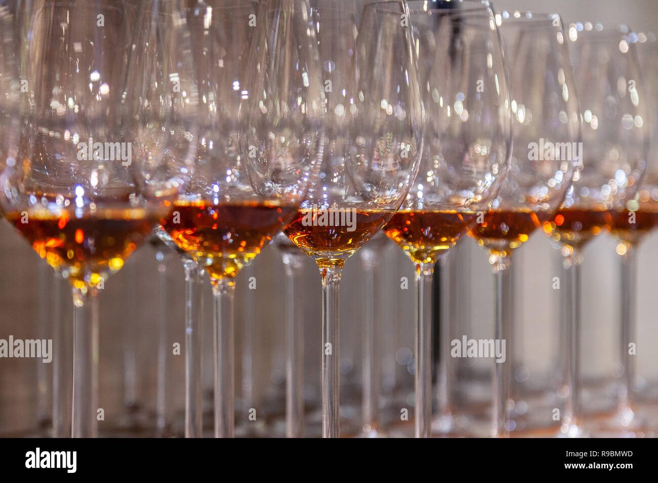 Many transparent crystal wine glasses with cognac stand in row on the ...