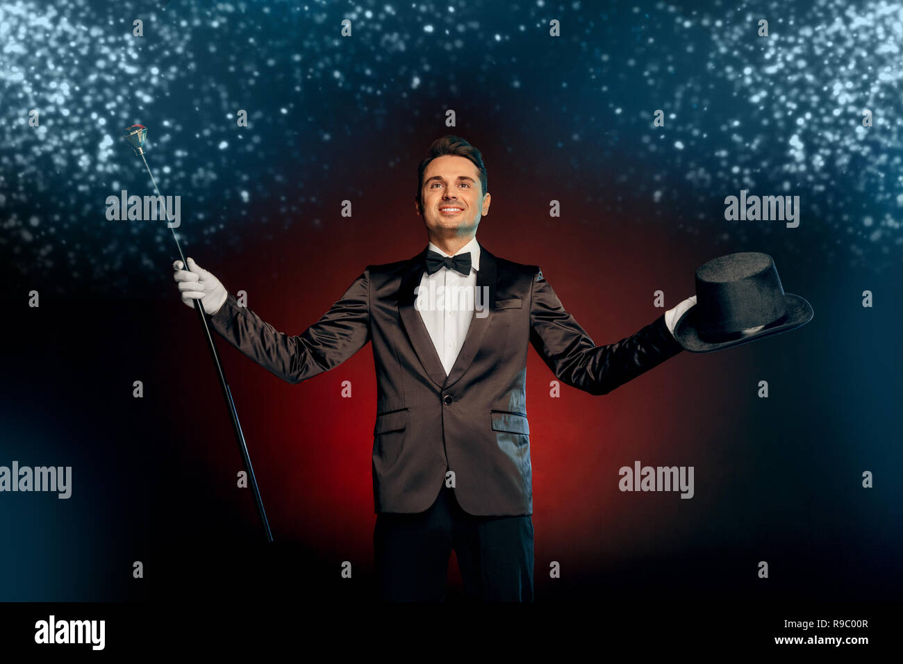 Professional showman wearing suit standing isolated on black and red ...