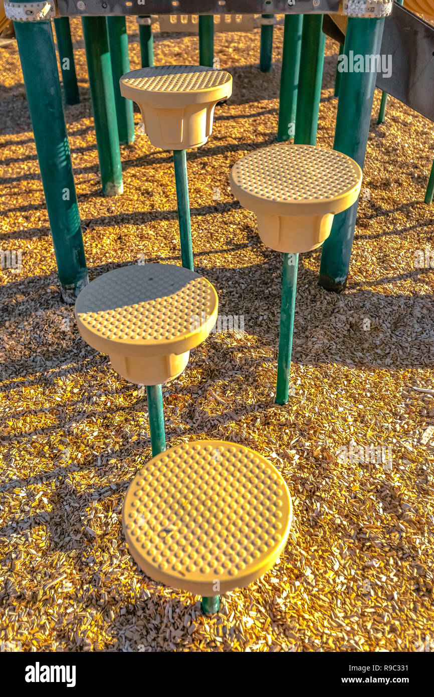 Round steps on poles of a playground Stock Photo - Alamy
