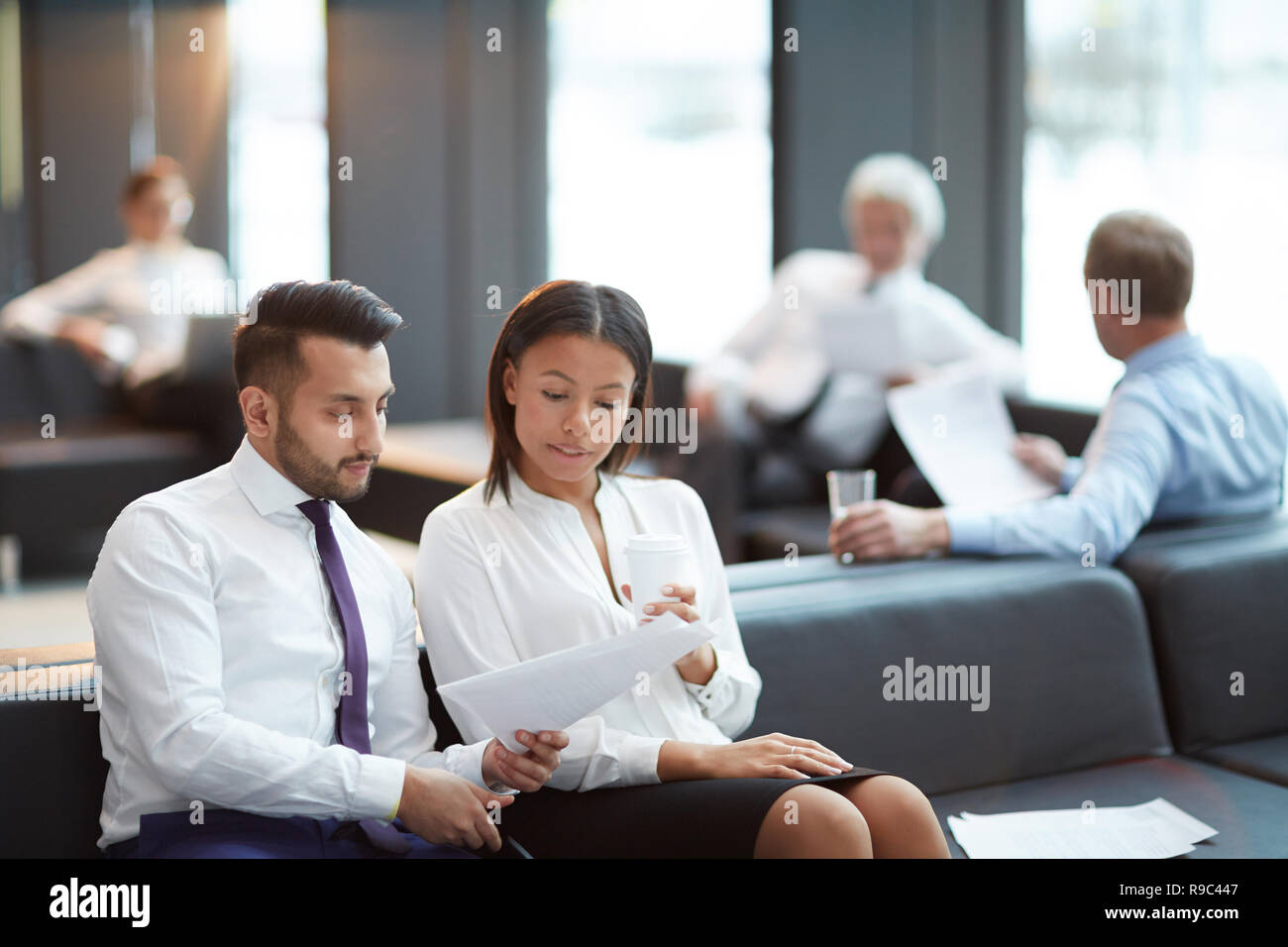 Discussing paper in lounge Stock Photo - Alamy