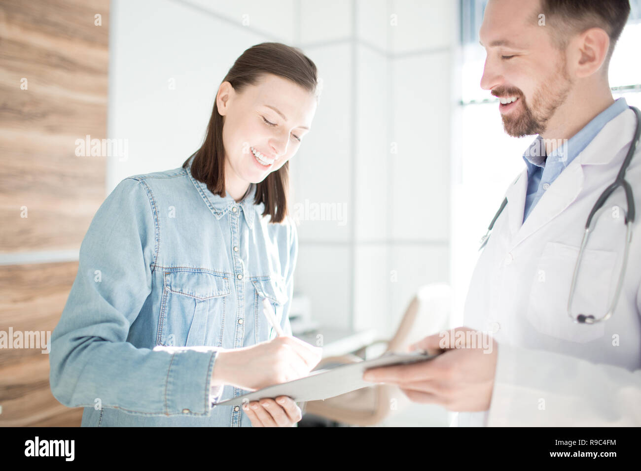 Patient signing document Stock Photo - Alamy