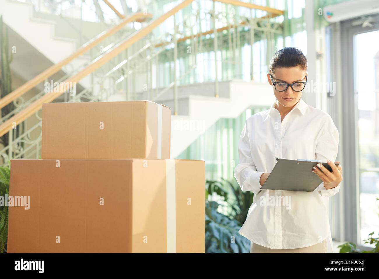 Busy lady checking delivery order Stock Photo - Alamy