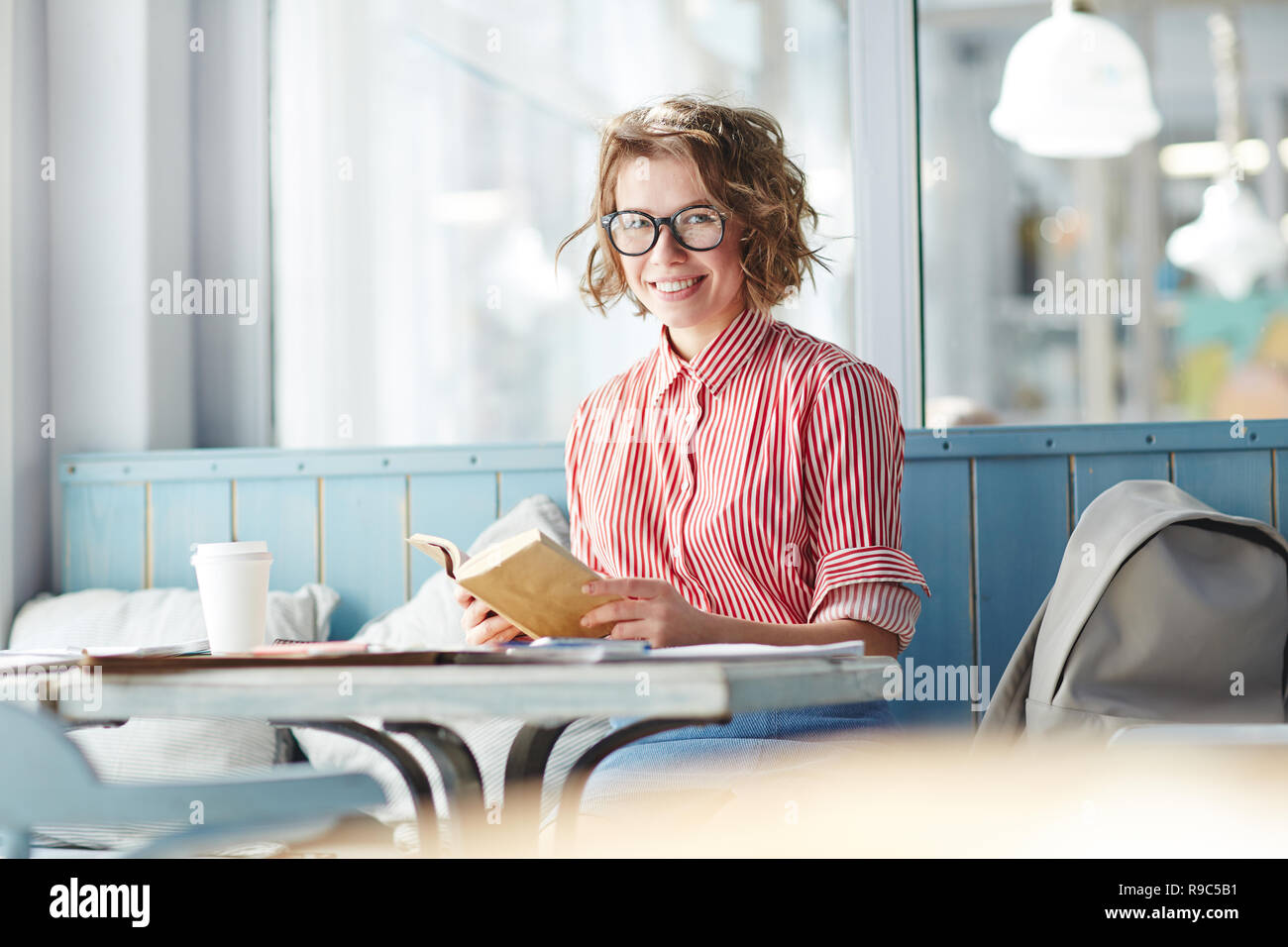 Reading book in cafe Stock Photo - Alamy