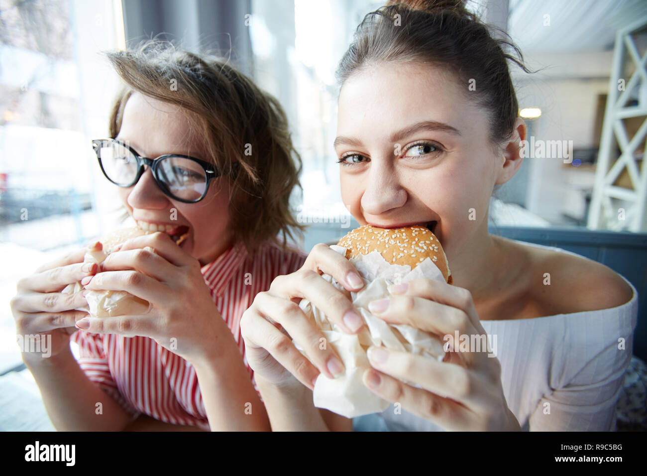 Student girl eating hamburger hi-res stock photography and images - Alamy