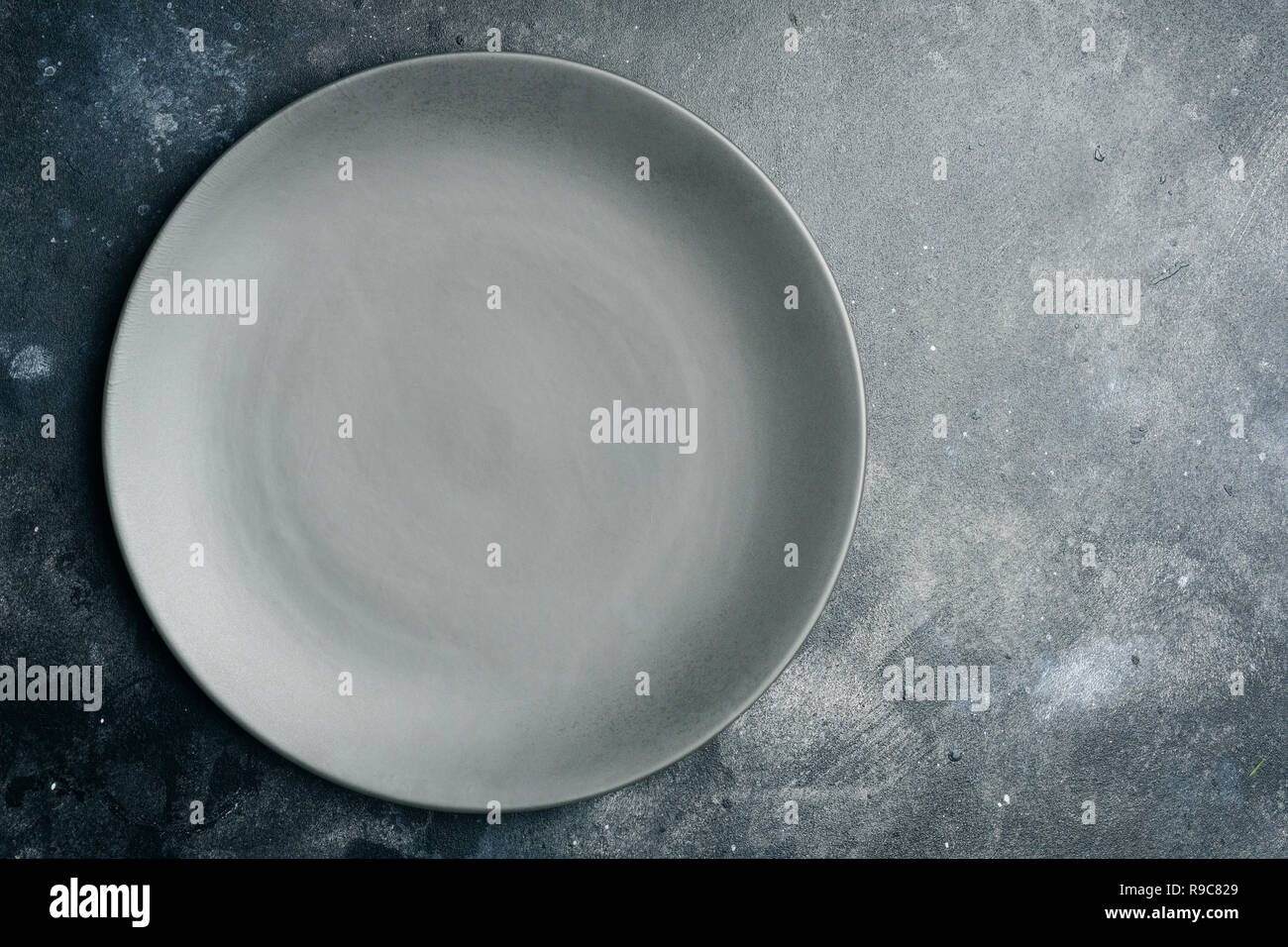 Gray empty plate (ceramic) on a gray stone background. Gray minimalism ...