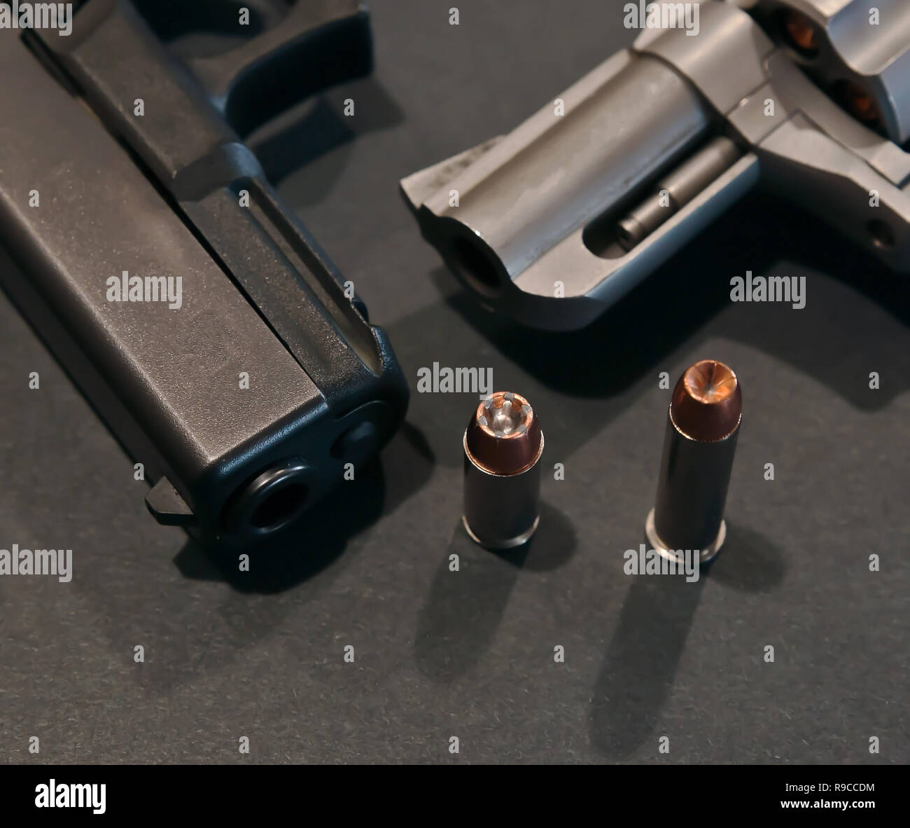 A black pistol with a 40 caliber hollow point in front of it next to a ...