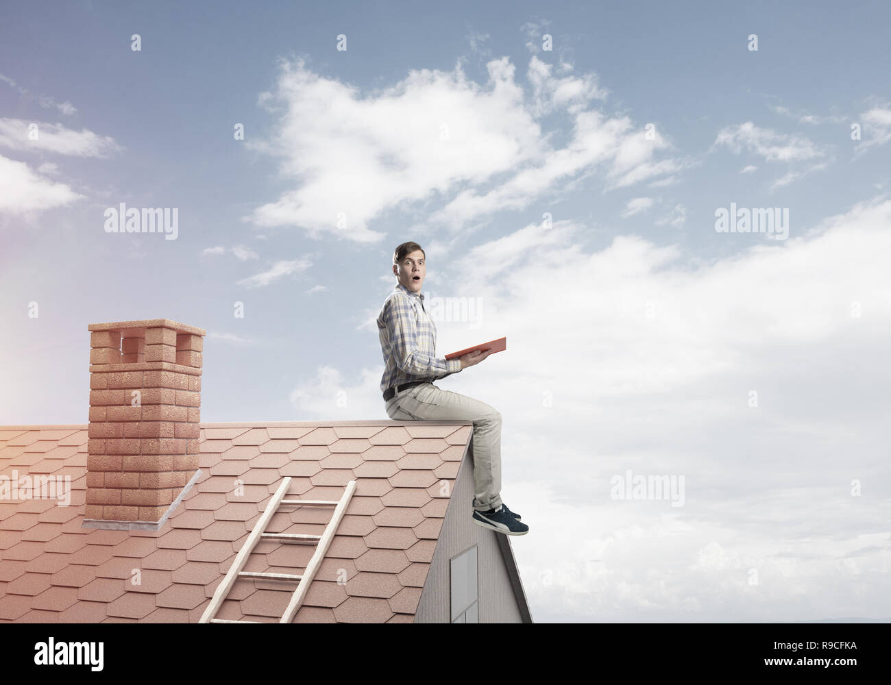 Handsome man on brick roof against cloud scape reading book Stock Photo ...