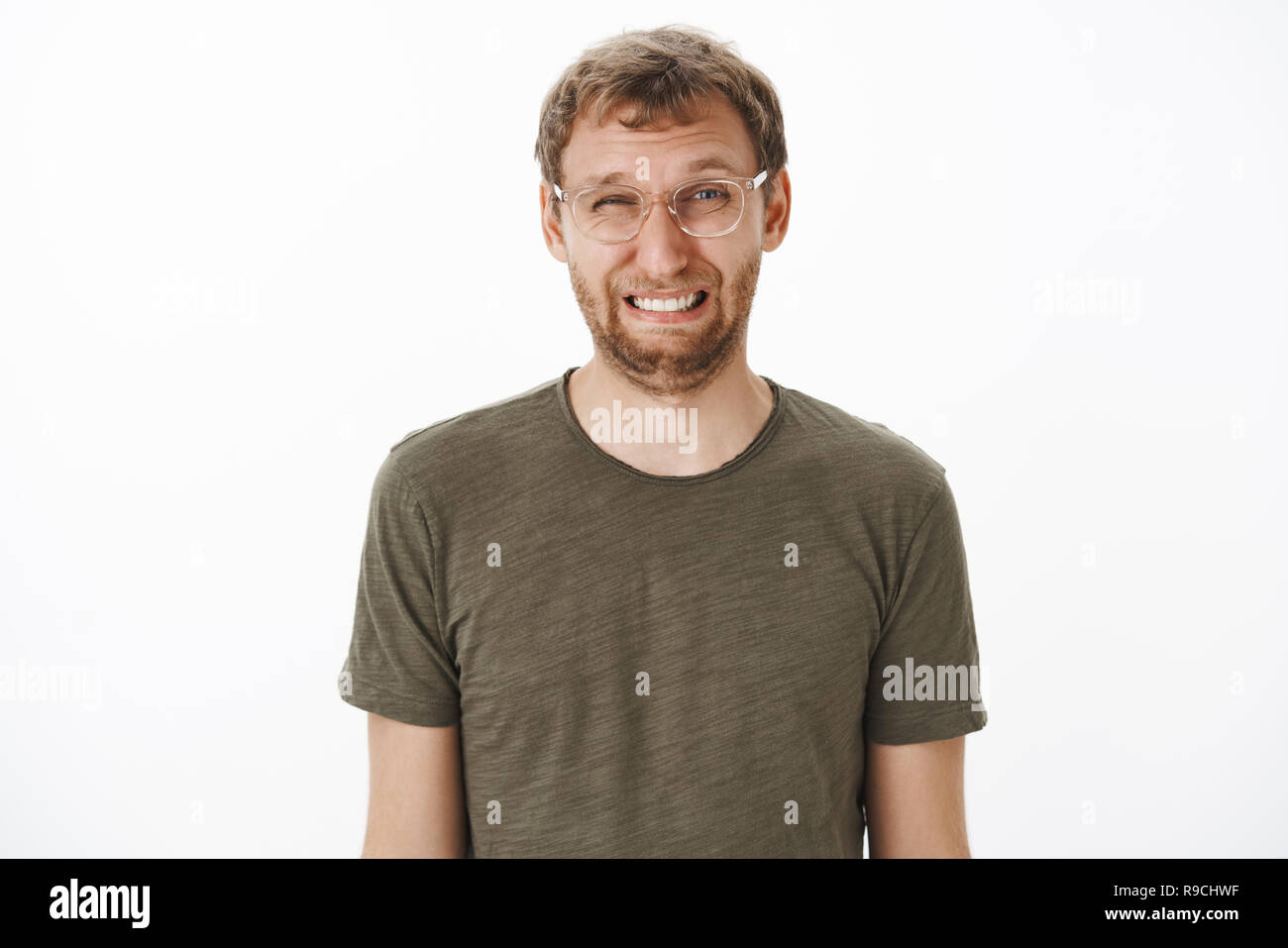 Guy squinting and making funny face eating sour lemon frowning and ...