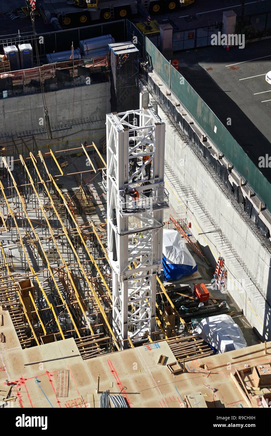 Workmen assemble a crane to be used in the construction of a new 42 ...