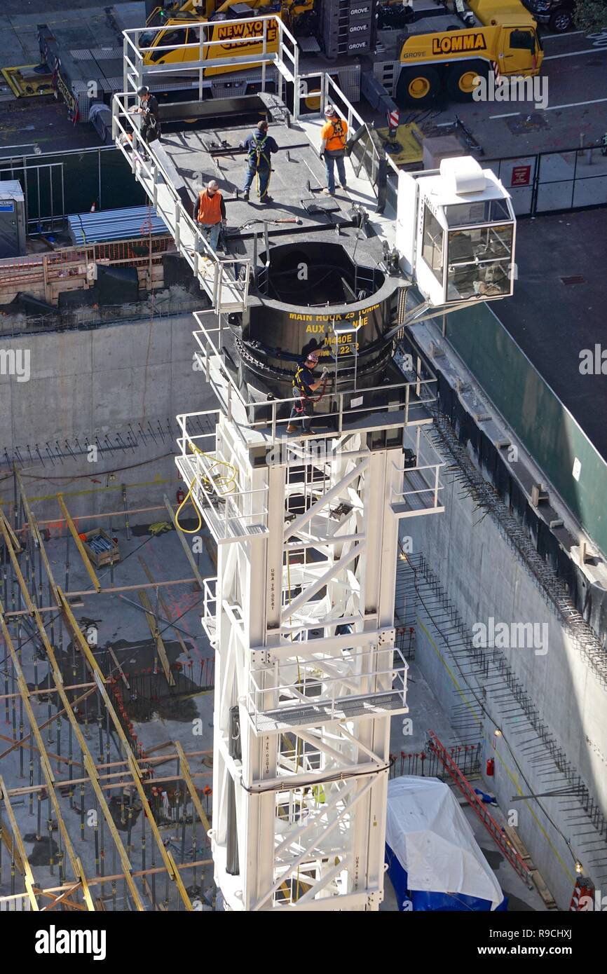 Workmen assemble a crane to be used in the construction of a new 42 ...