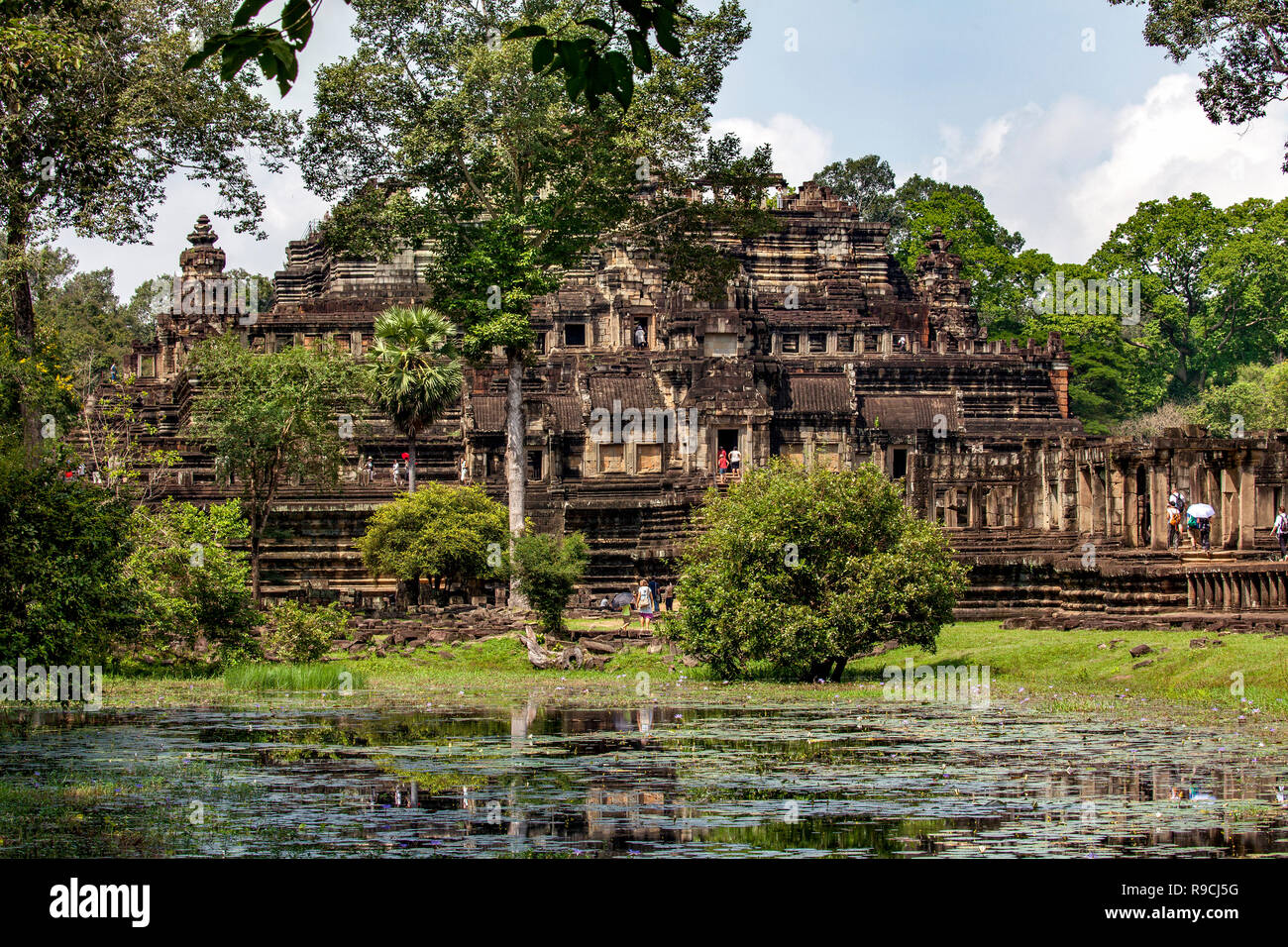 Tourists explore 12th century temple complex ruins of Angkor Thom in ...