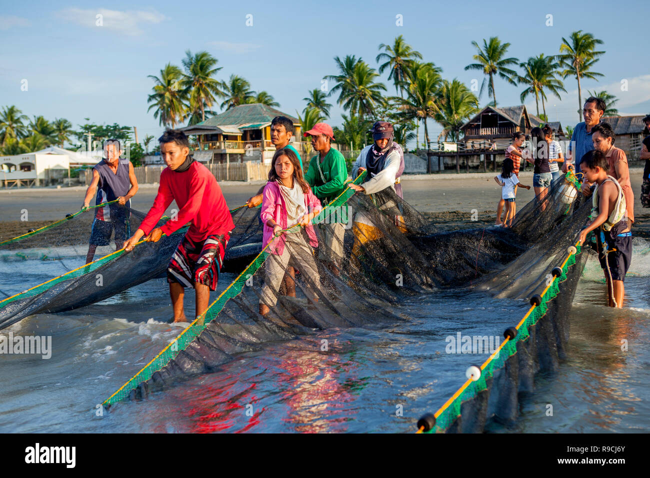 Men, women and children from the local fishing cooperative haul in ...