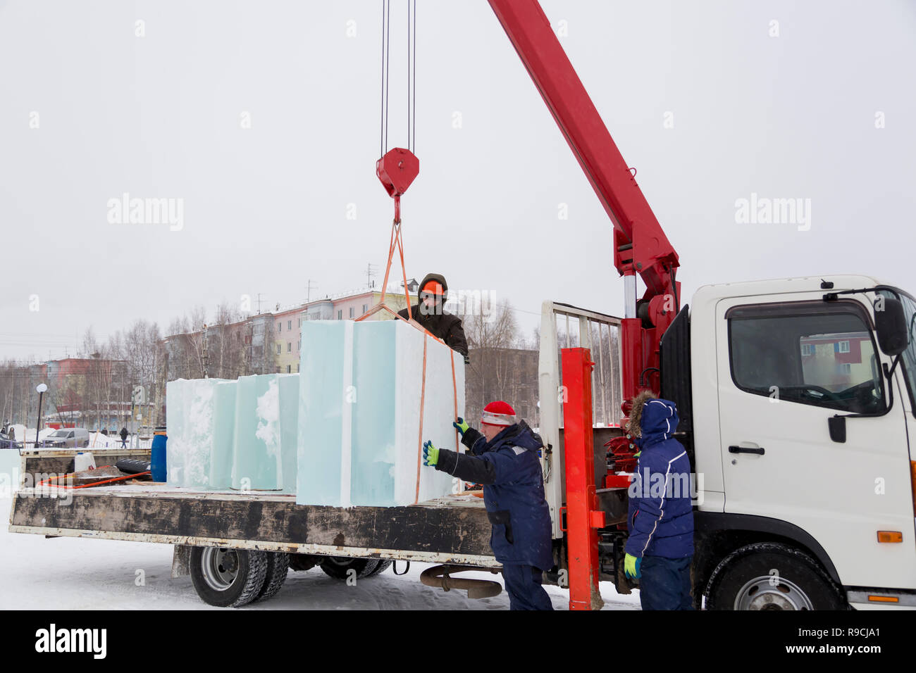 Assemblers unload ice panels from a car using a crane Stock Photo - Alamy