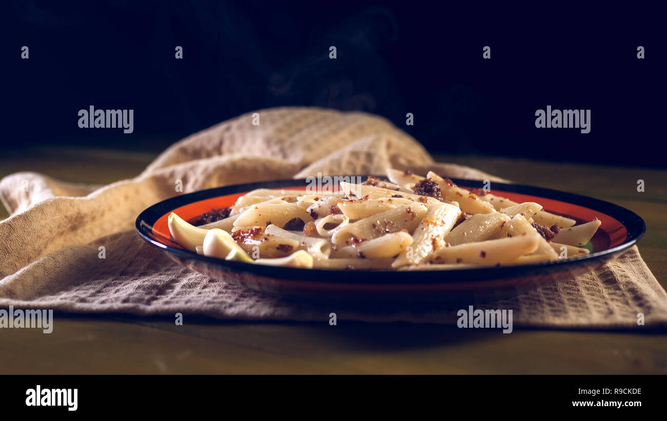 pasta with minced meat, garlic and onion in navy-style on yellow wooden ...