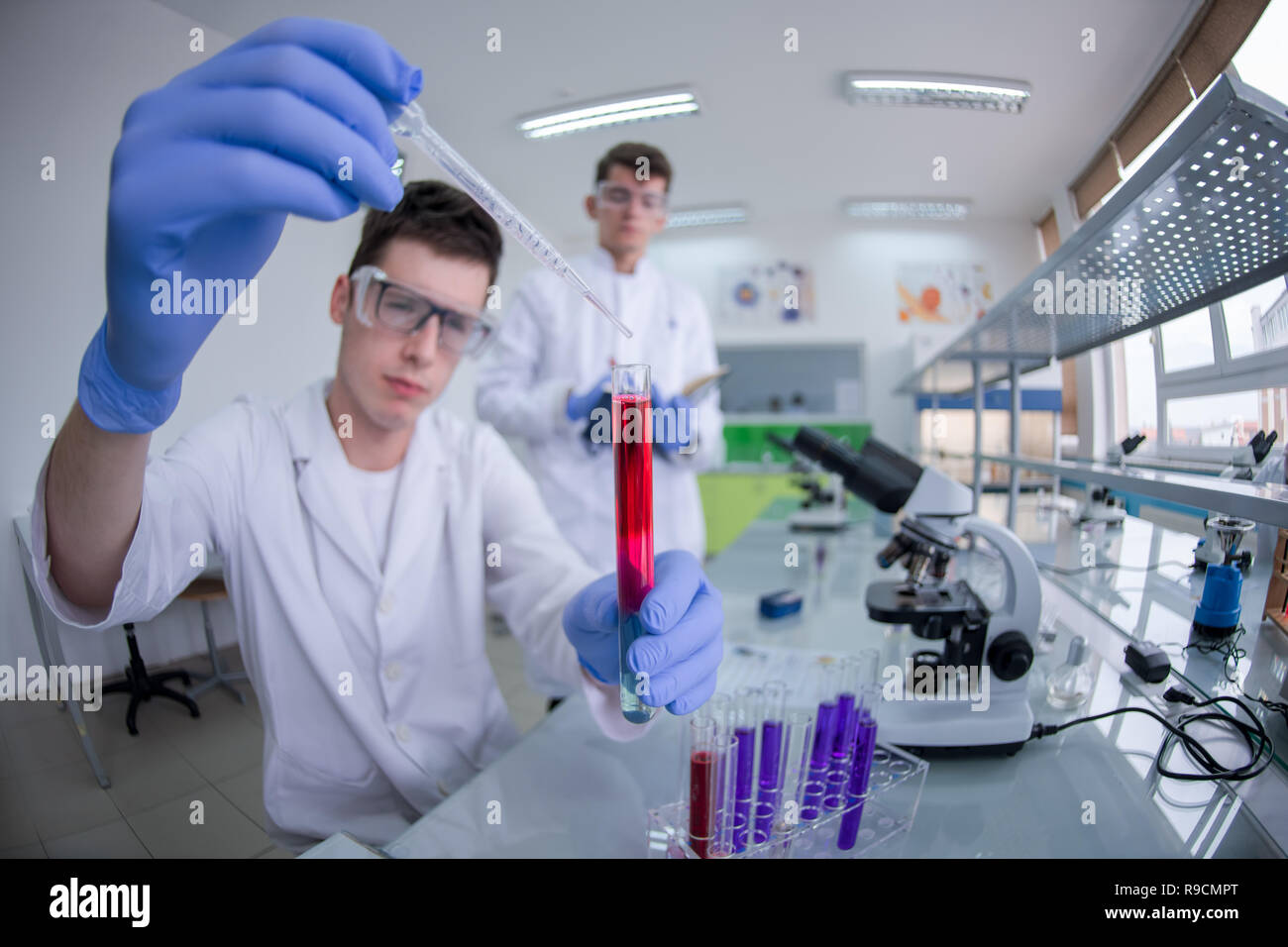Group of young medical students doing research together in chemistry ...