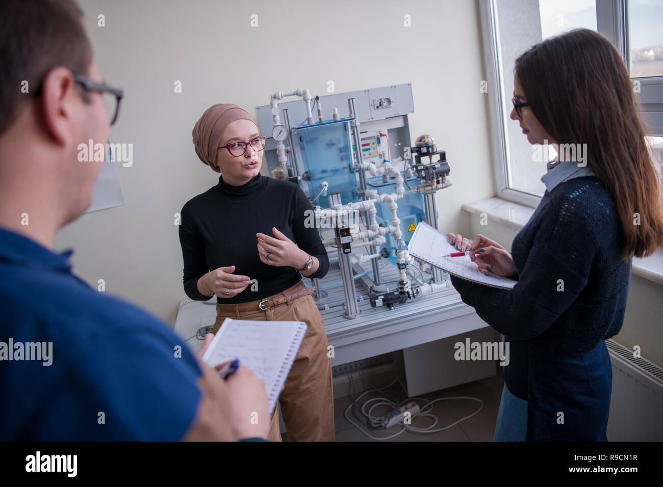 Group of students doing technical vocational practice with young female ...