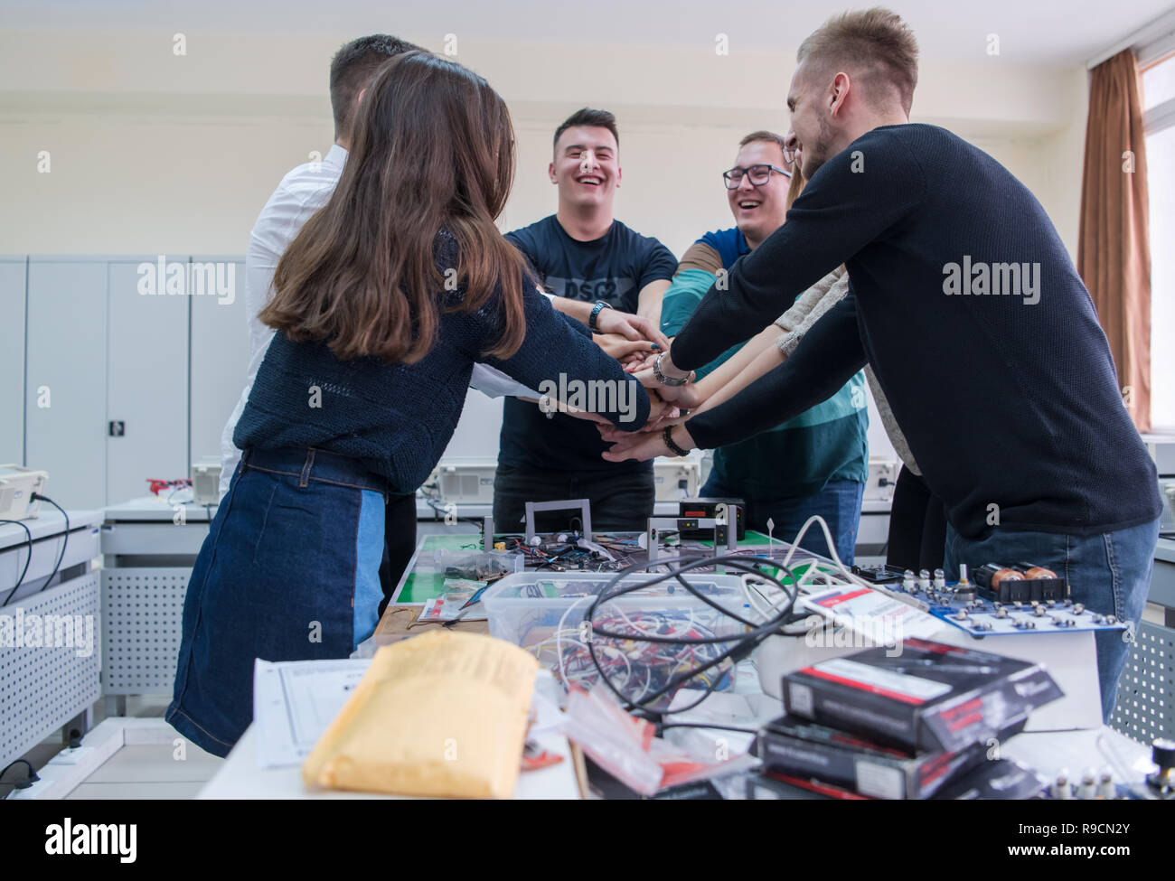 Group of young students in electronics classroom celebrating ...